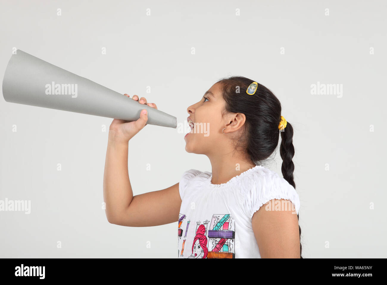 Girl shouting into a paper megaphone Stock Photo - Alamy
