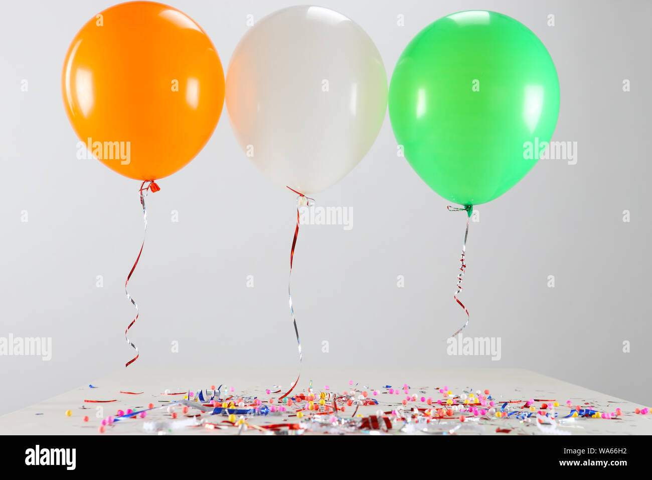 Tricolor balloons floating over confetti on a table Stock Photo - Alamy