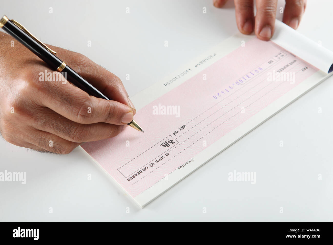 Person's hand signing a cheque book Stock Photo - Alamy