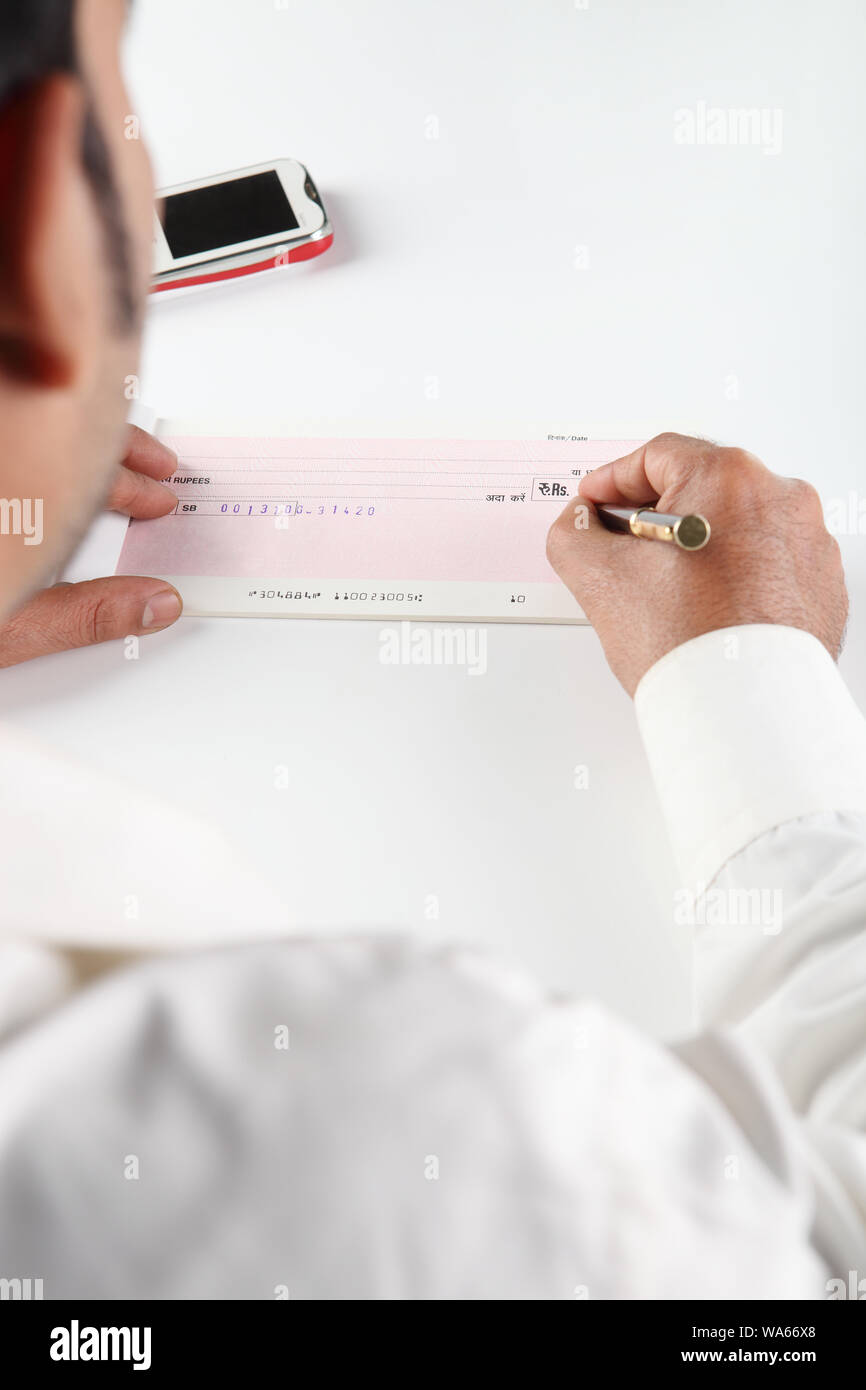 Businessman signing a cheque book Stock Photo - Alamy