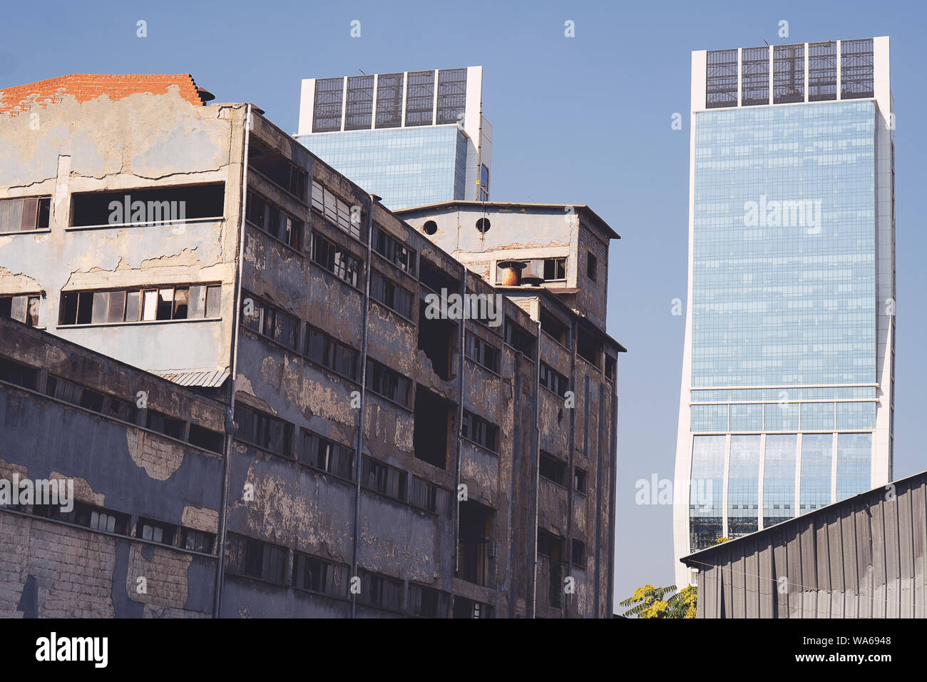 A new modern glass skyscraper and a destroyed old building. Old area ...