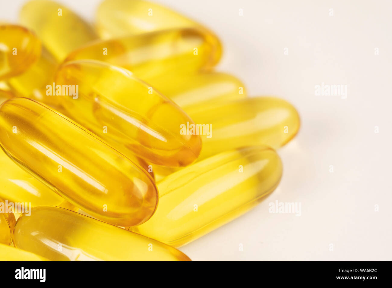 Pile of gold color fish oil capsules isolated on white background view ...