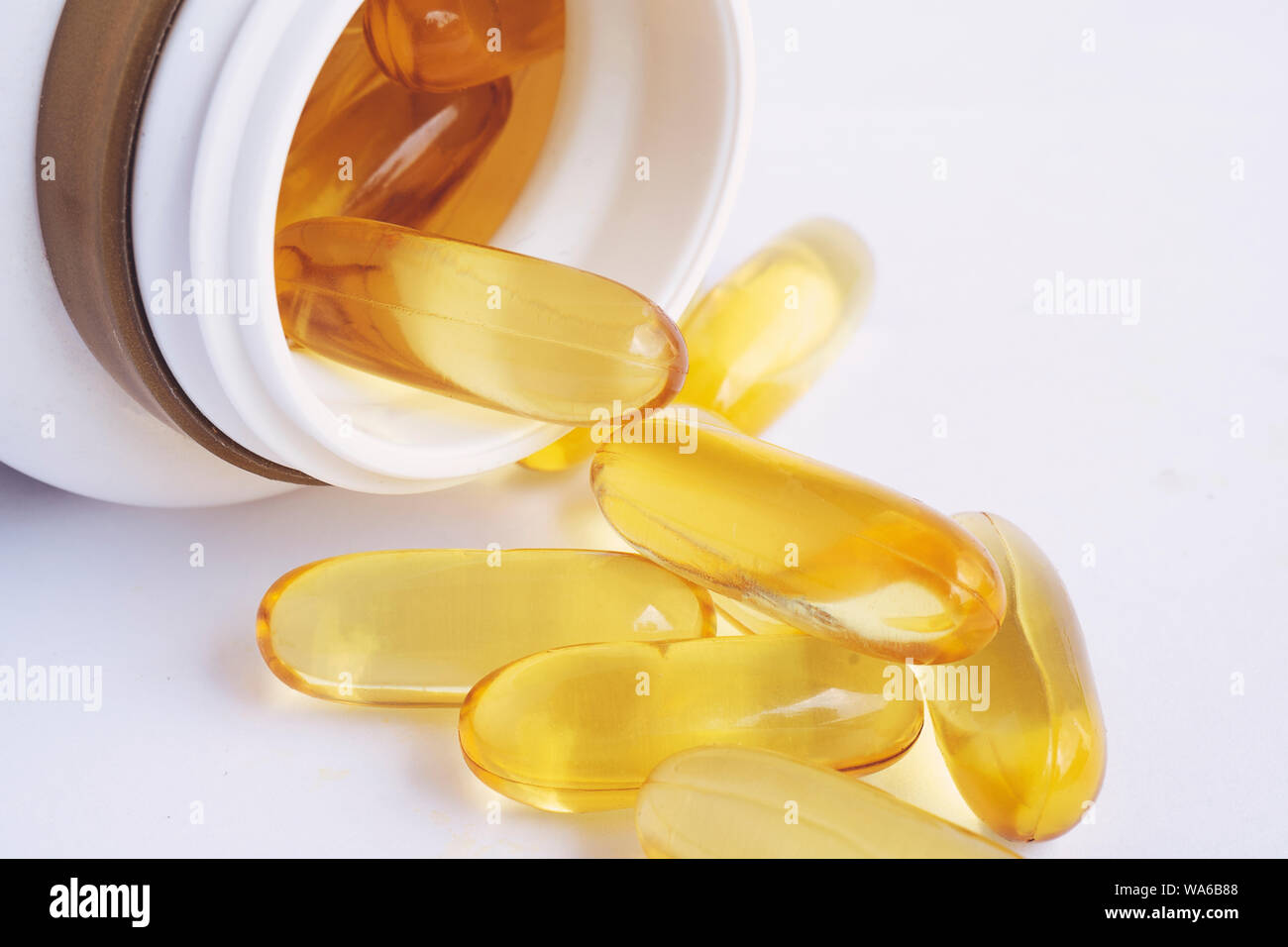 Pile of omega 3 fish oil capsules spilling out of a bottle Stock Photo ...