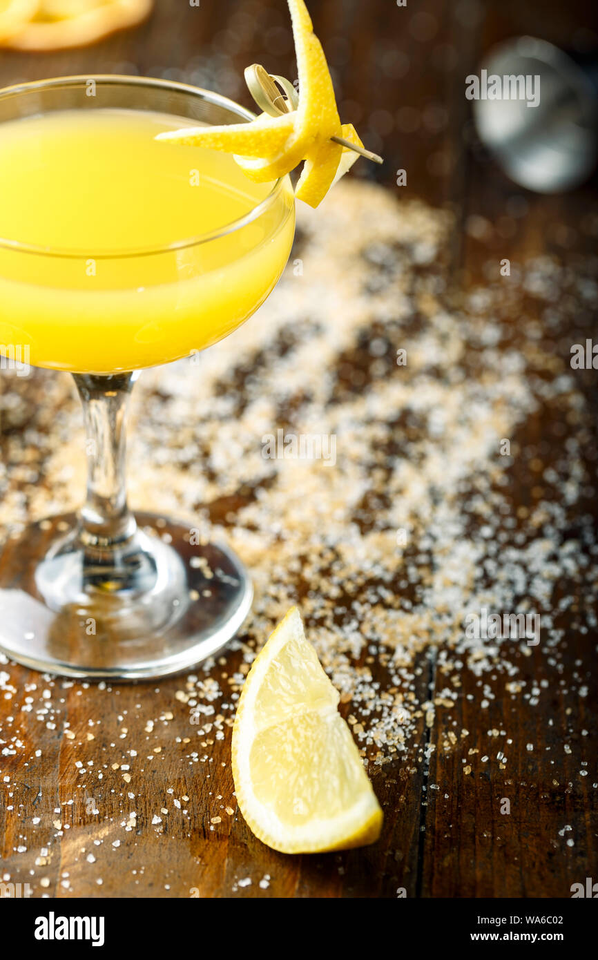 beautiful yellow alcoholic cocktail, decorated with orange peel. on a ...