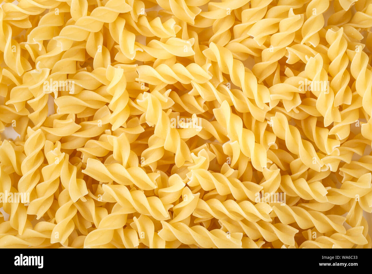 uncooked spiral pasta scattered as background. traditional italian food ...