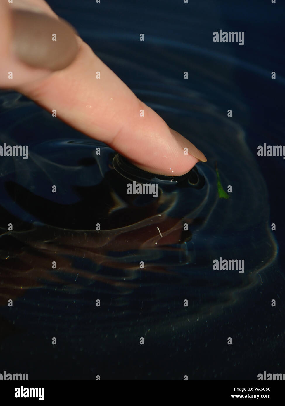 Close up of finger touching water Stock Photo - Alamy