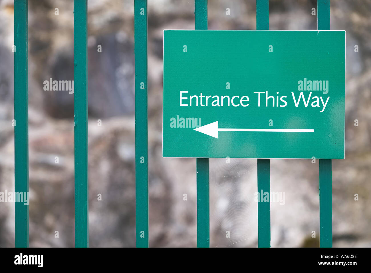 Entrance this way directional arrow sign Stock Photo - Alamy