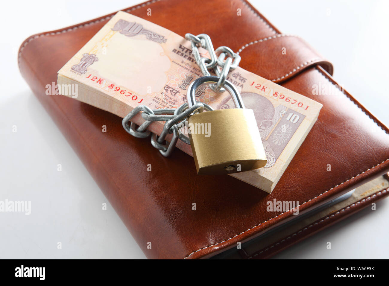 Banknotes wrapped of a chain with a padlock Stock Photo - Alamy