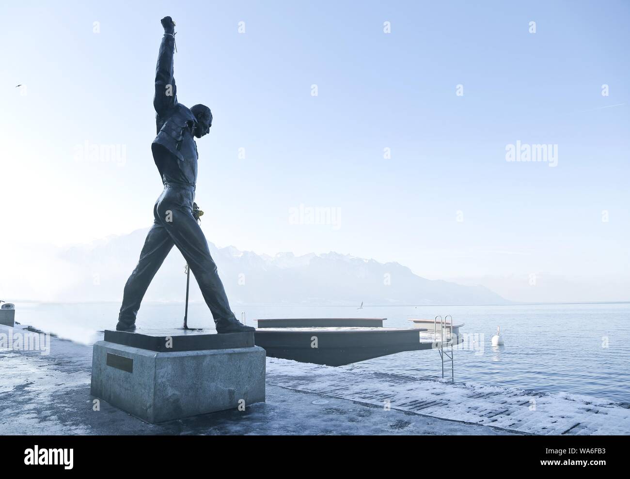 Shot of gray metal statue of a male raising his hand Stock Photo - Alamy