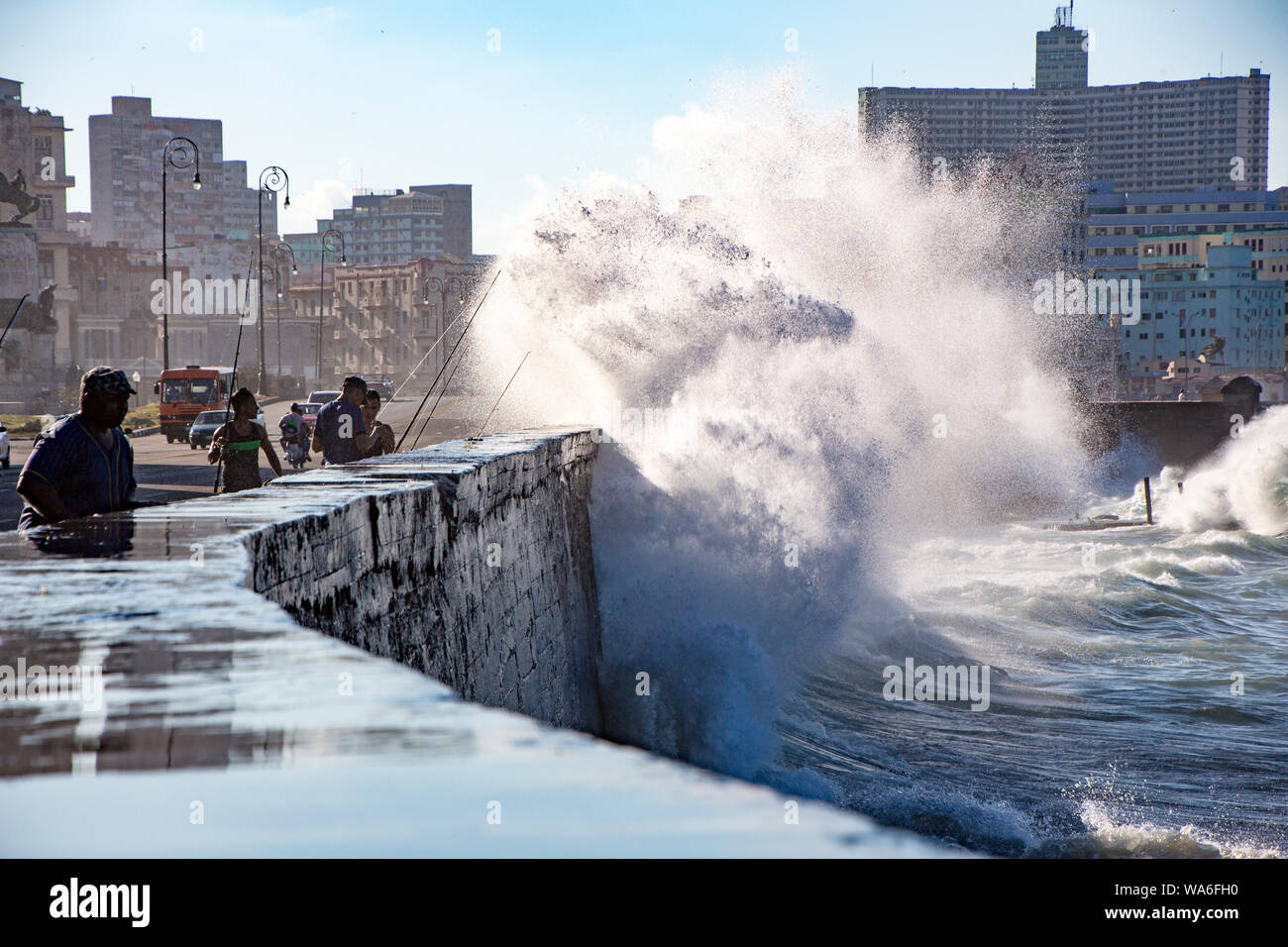 Havana, Cuba, Nov 20, 2017 - Waves crash over the Malecon wall as men ...