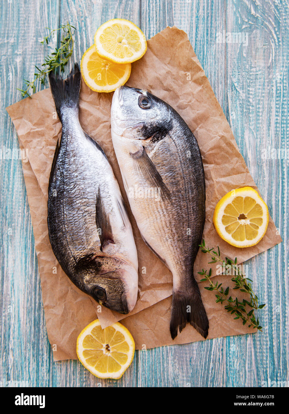 Fresh fish dorado. Dorado and ingredients for cooking on a table Stock ...