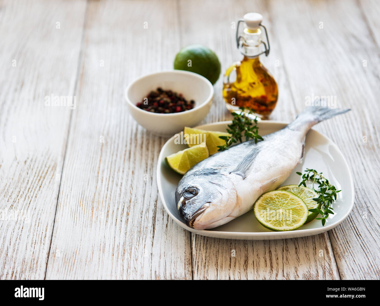 Fresh fish dorado. Dorado and ingredients for cooking on a table Stock ...