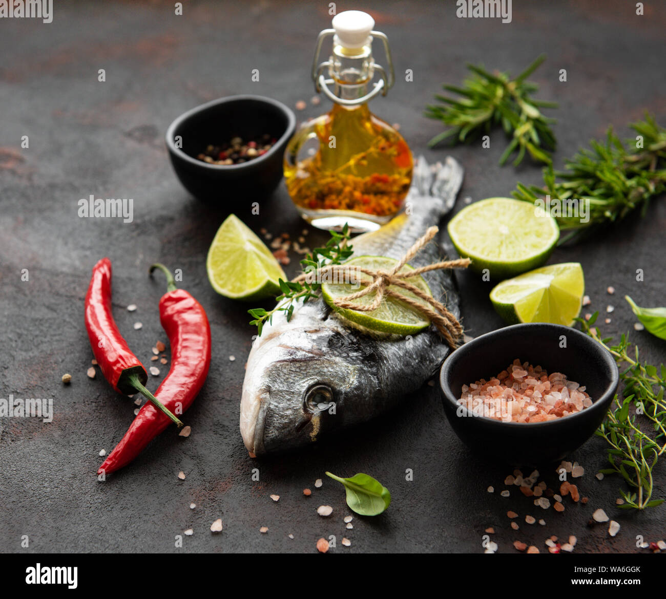 Fresh fish dorado. Dorado and ingredients for cooking on a table Stock ...