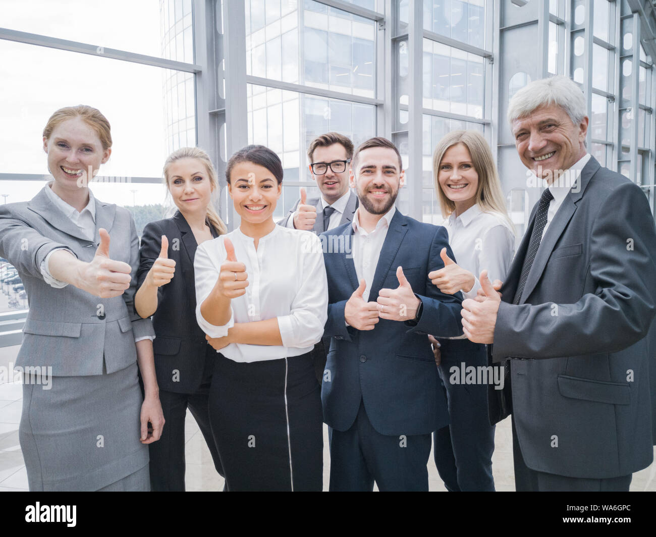 Portrait business people team showing thumbs up , office staff standing in lobby Stock Photo - Alamy