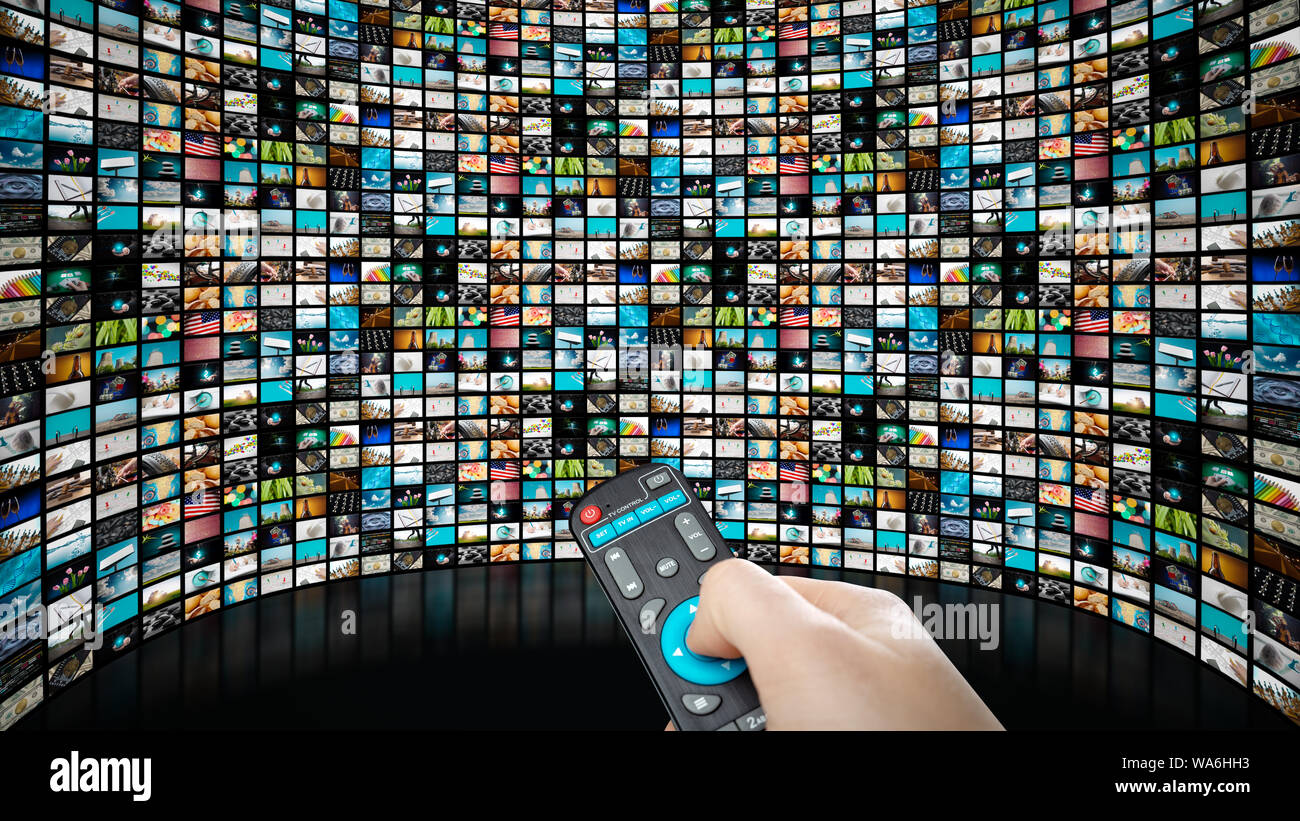 Image of big screen with many channels, hands of man with remote ...