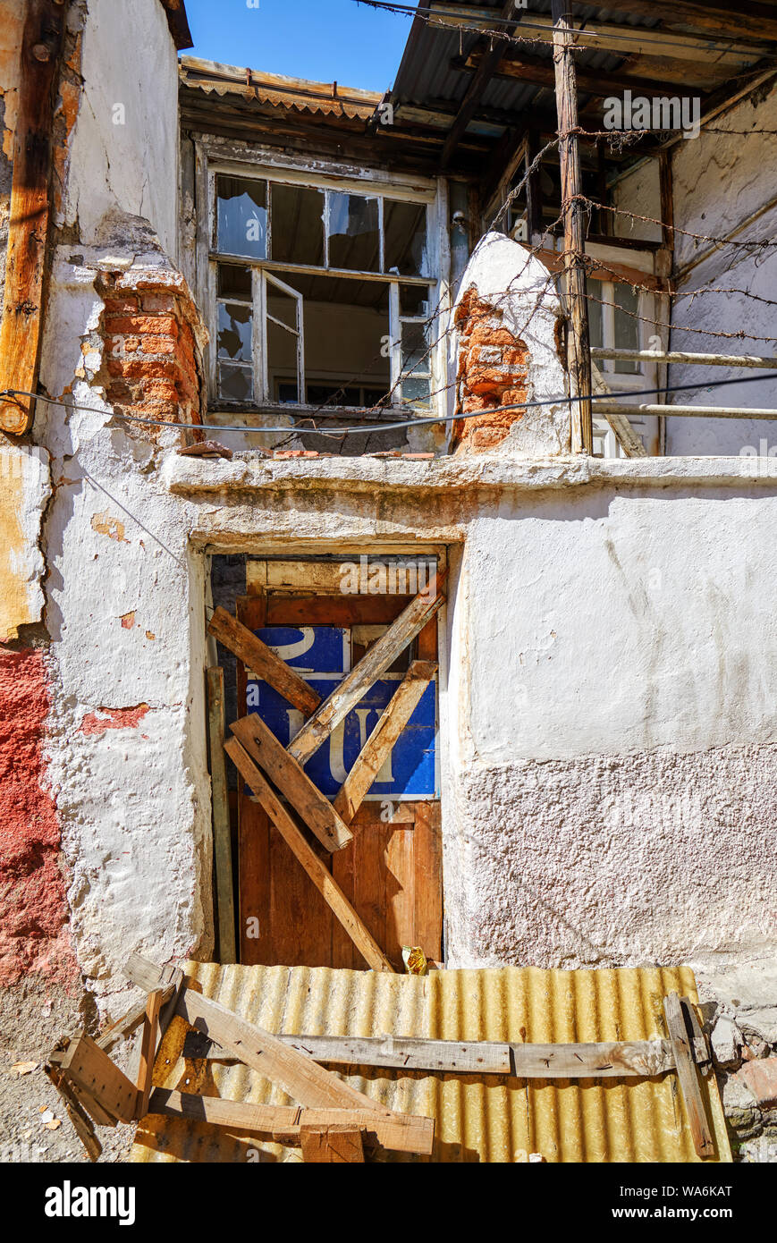 Abandoned shack house with barred shut door and broken glass window in ...