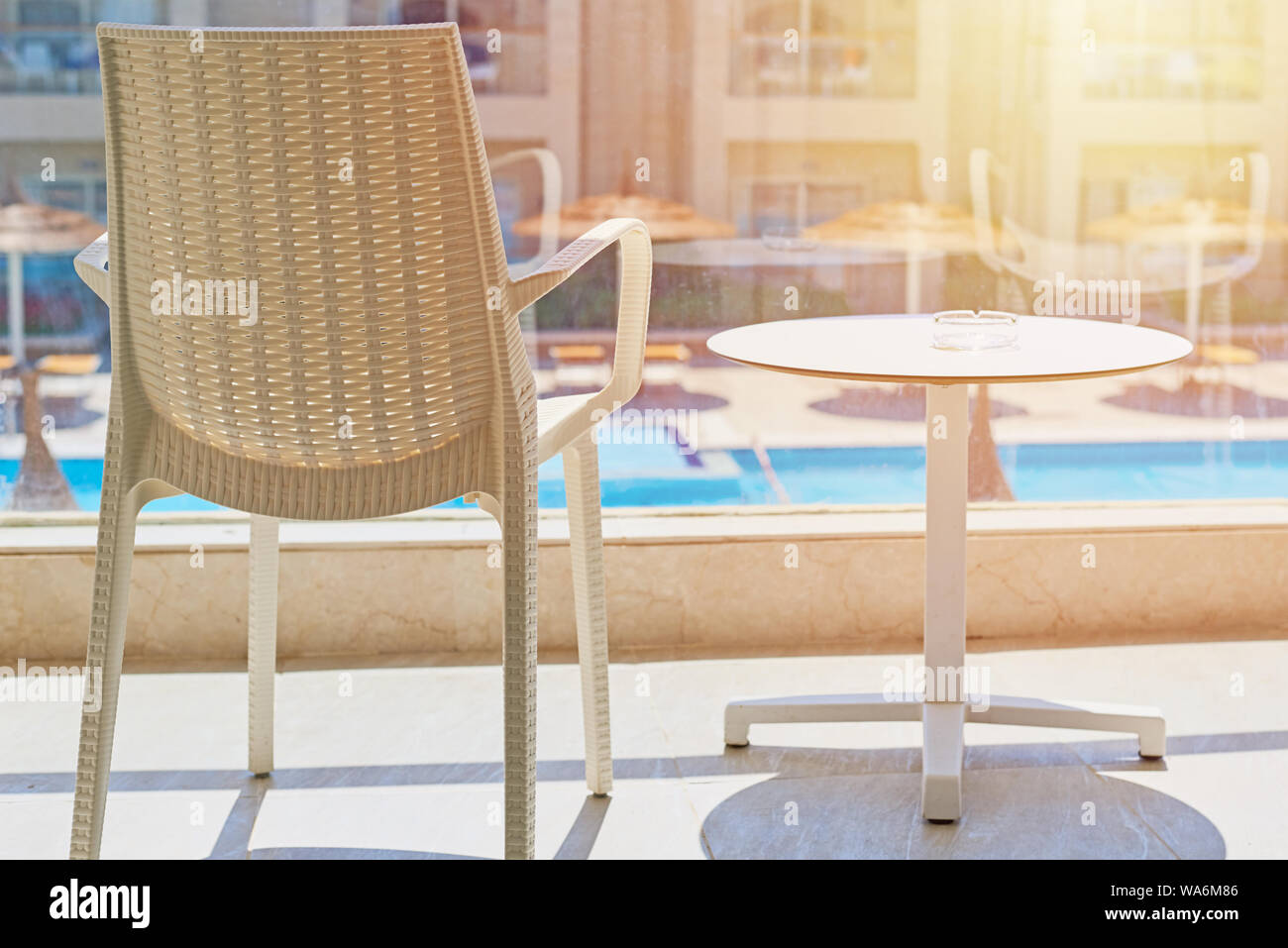 empty chair and table on balcony against swimming pool background Stock ...