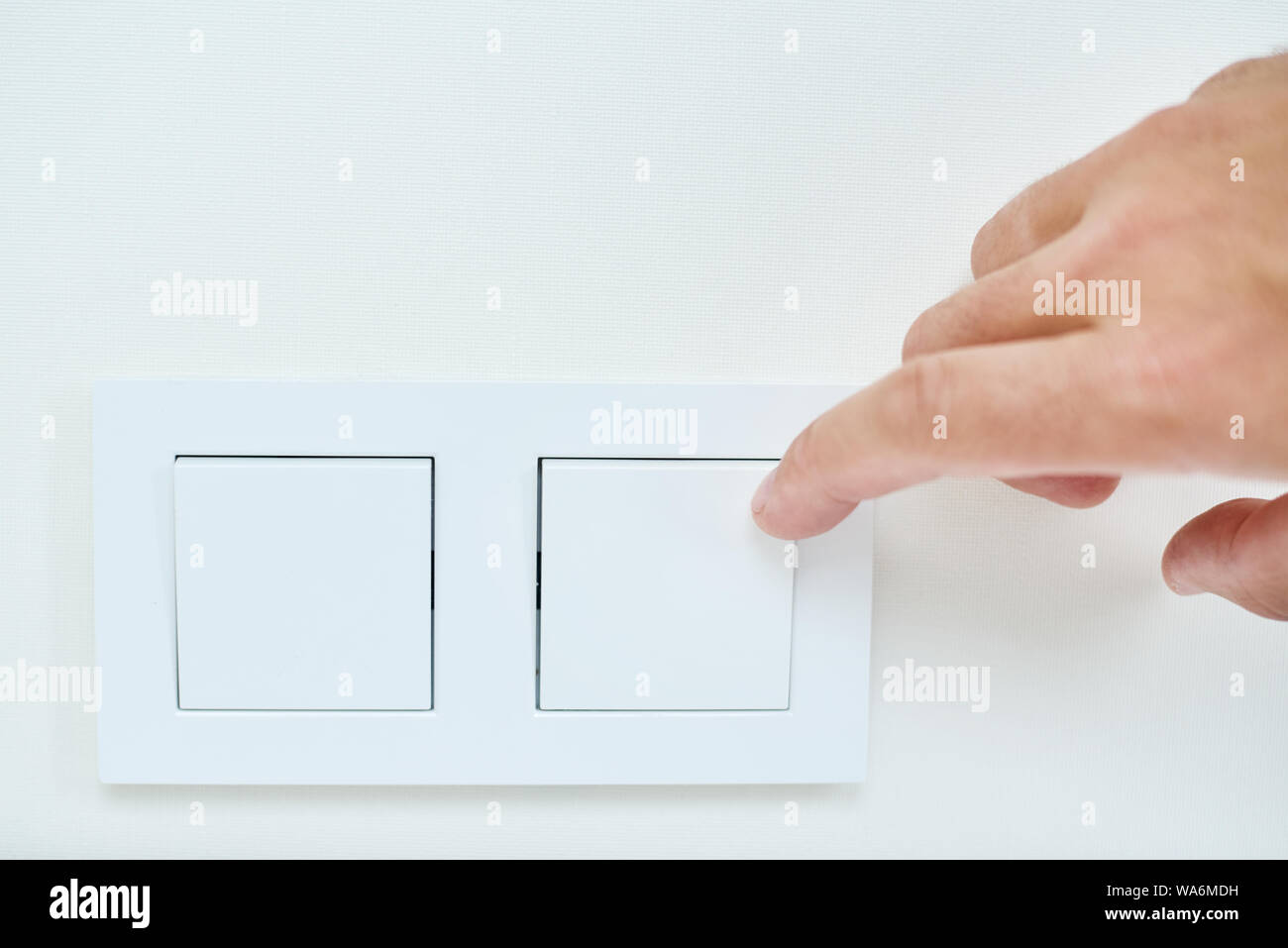 Hand is turning on or off on light switch, close up Stock Photo - Alamy