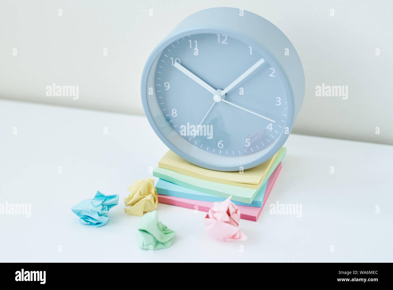 Gray round alarm clock and colorful sticky notes on white background ...