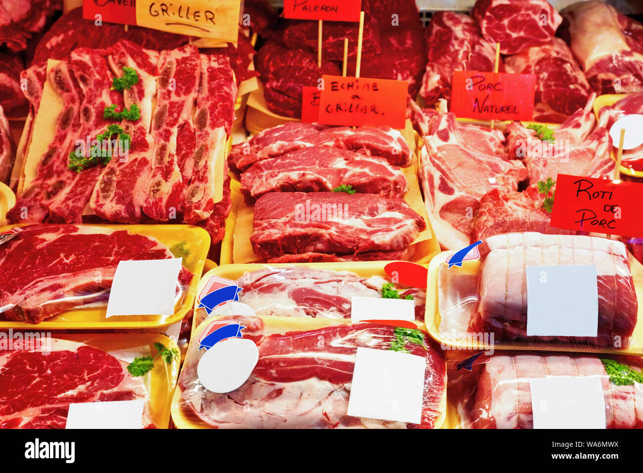 Different types of packed raw red meat displayed at the supermarket ...