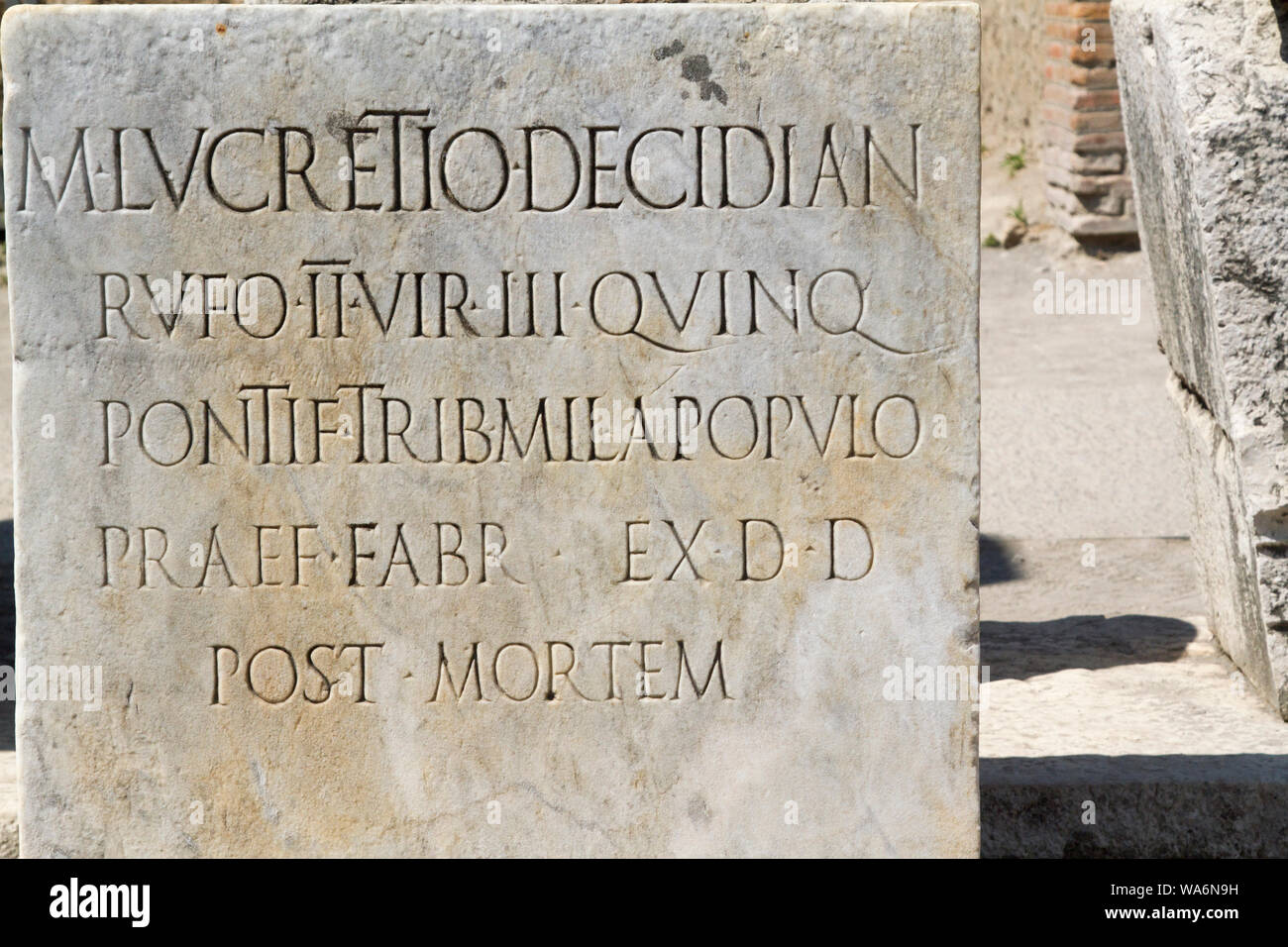 Engraved latin script stonework in the ruined Roman city of Pompeii ...