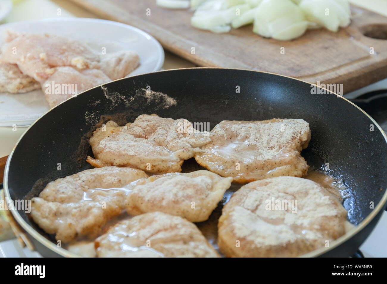 Frying Raw breaded chicken fillet on fry pan. Making dinner meal Stock ...