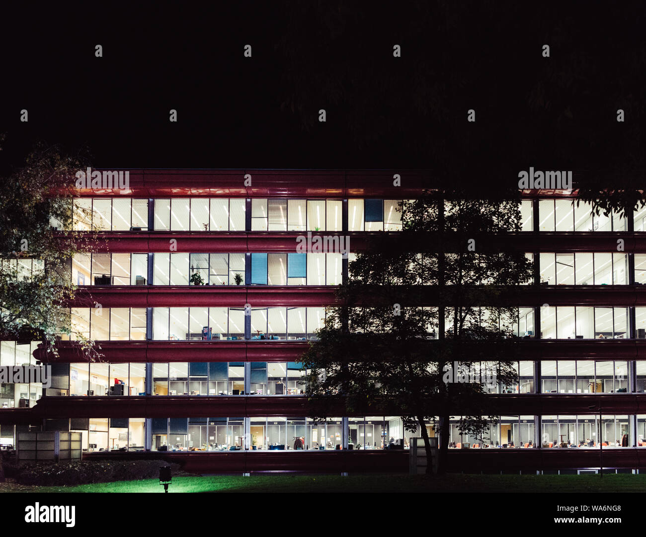 Empty office building at night with lights still on. Noise reduced ...