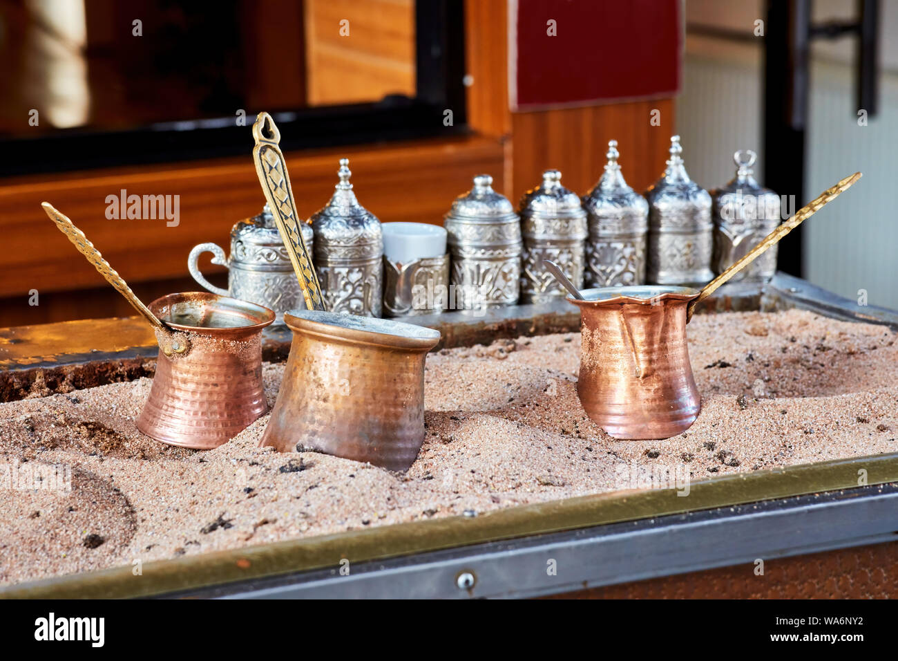 Traditional Turkish coffee cooked in hot sand and three copper cezve ...