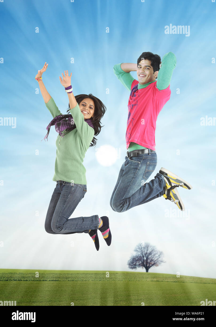 Young couple jumping in air and smiling Stock Photo - Alamy