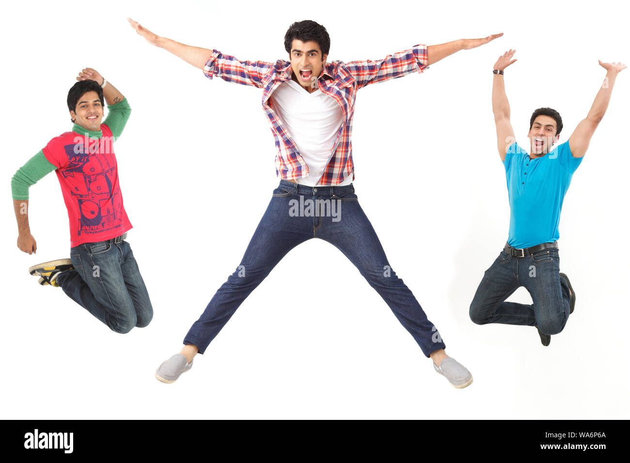 Young men jumping in mid air and smiling Stock Photo - Alamy