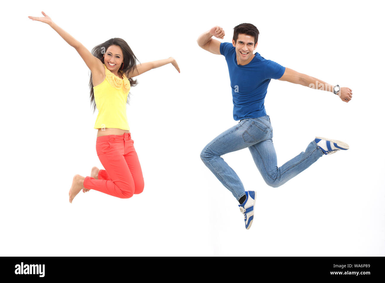 Young couple jumping in air and smiling Stock Photo - Alamy