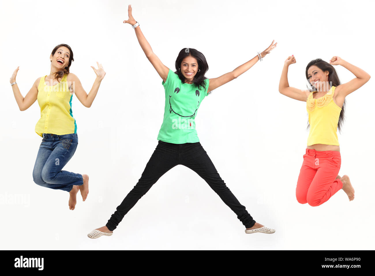 Young women jumping in mid air and smiling Stock Photo - Alamy