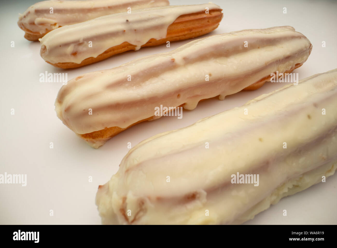 Eclairs with white glaze. Homemade eclairs cakes Stock Photo - Alamy