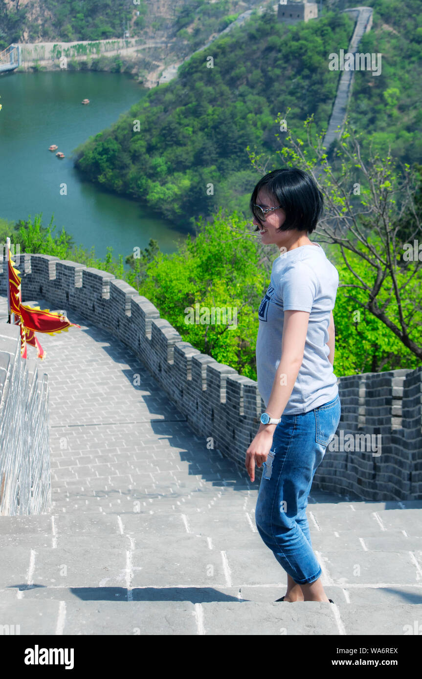 A chinese woman walking up the stone steps on the great wall of china ...