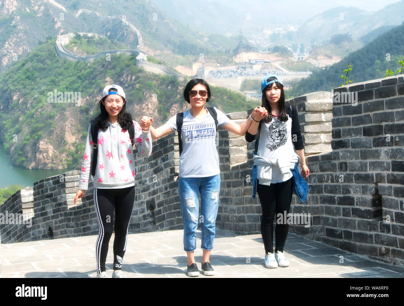 Three chinese woman having fun on the great wall of china at huanghua ...