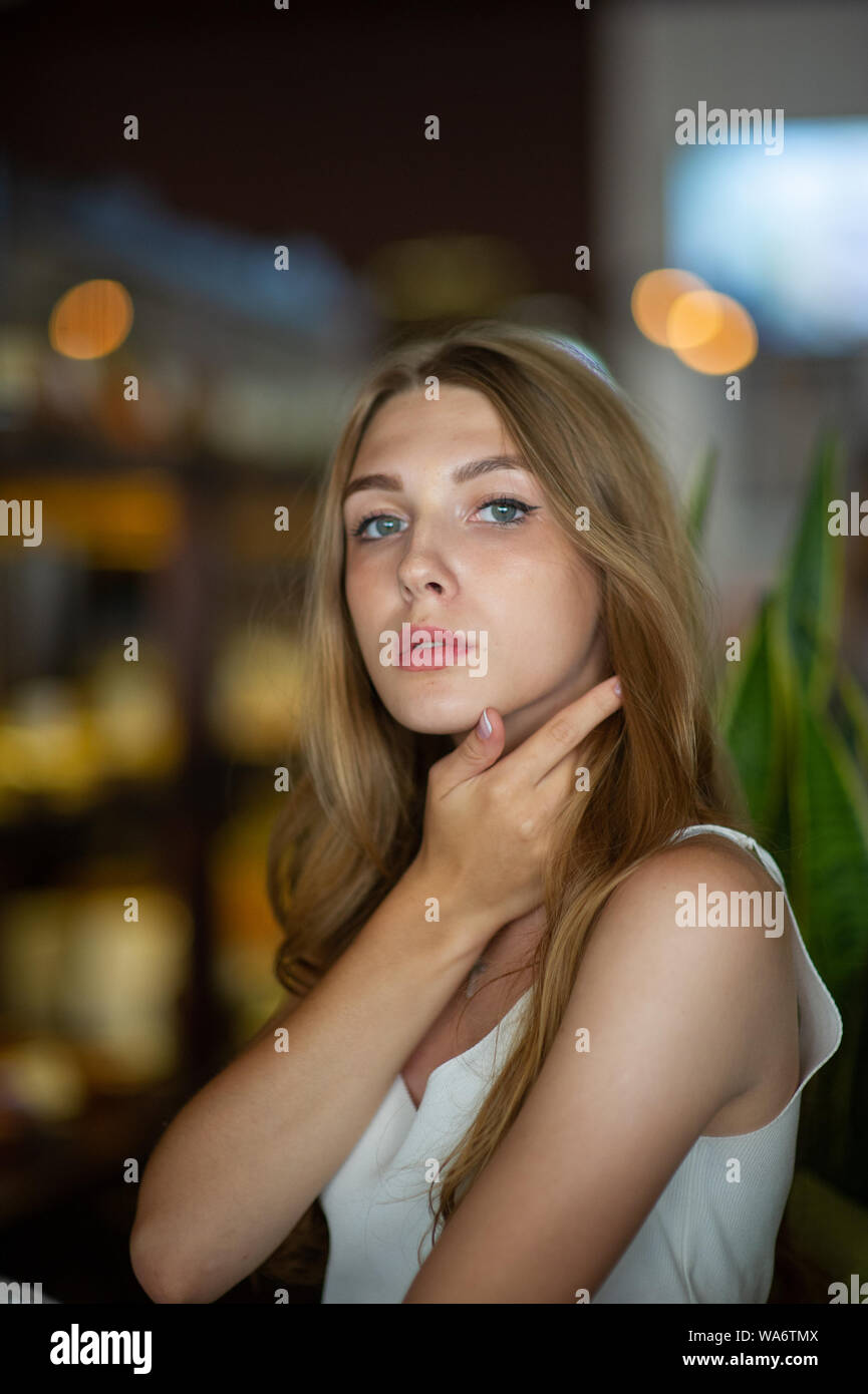 Girl with blue eyes sitting on urban cafe. woman with brown wavy ...