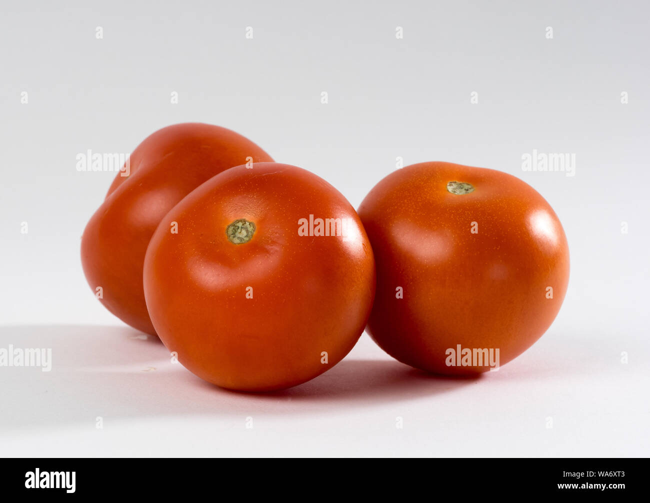 Three whole red tomatoes Stock Photo - Alamy