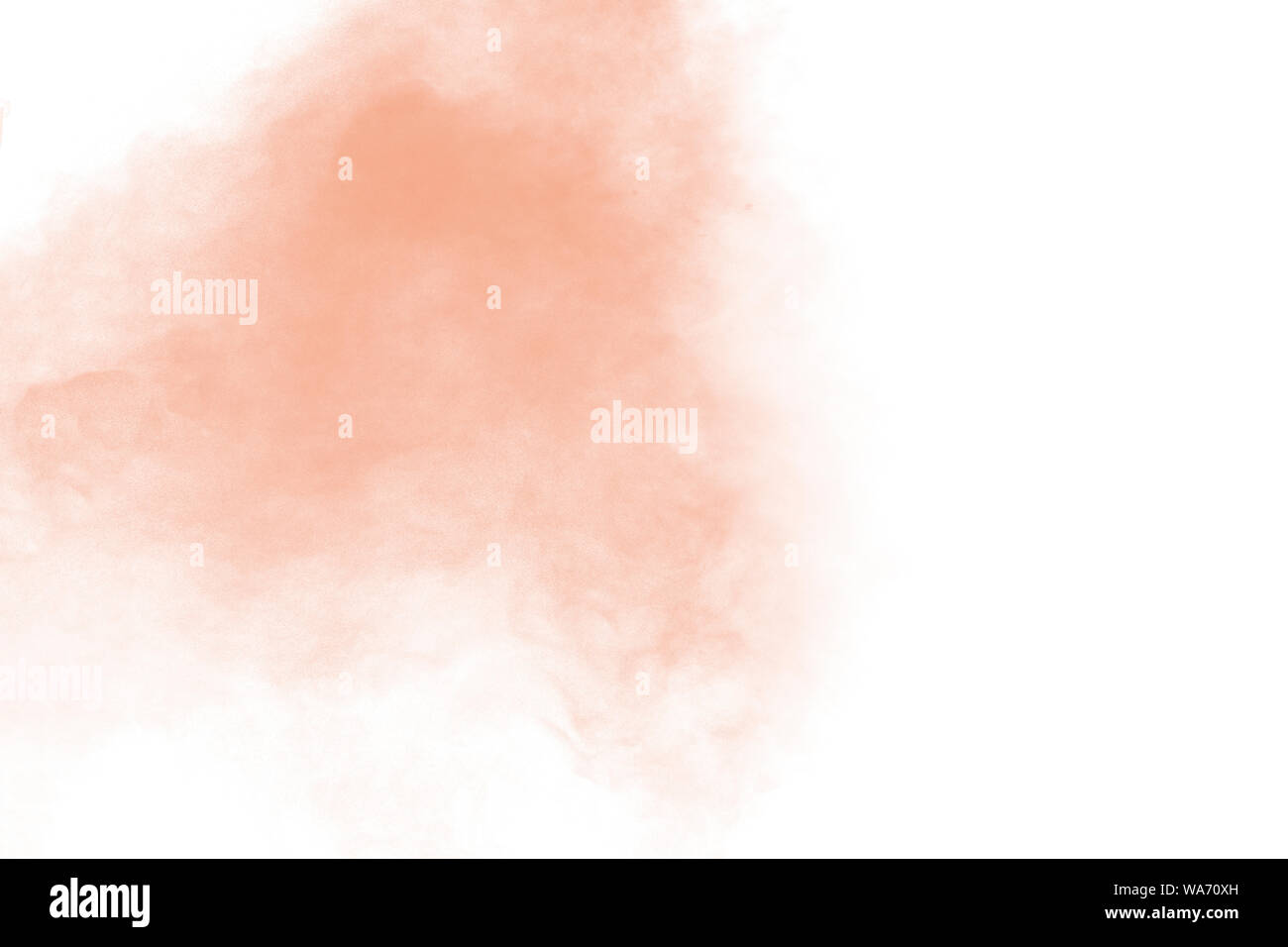 Abstract light orange powder explosion on white background. Freeze ...