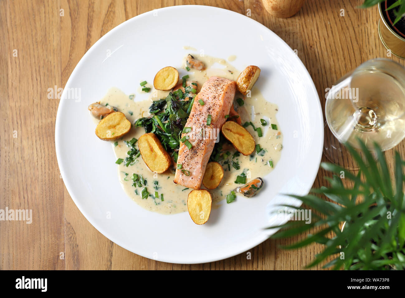 Elegant, exquisite dinner dish served on white plates with a glass of ...