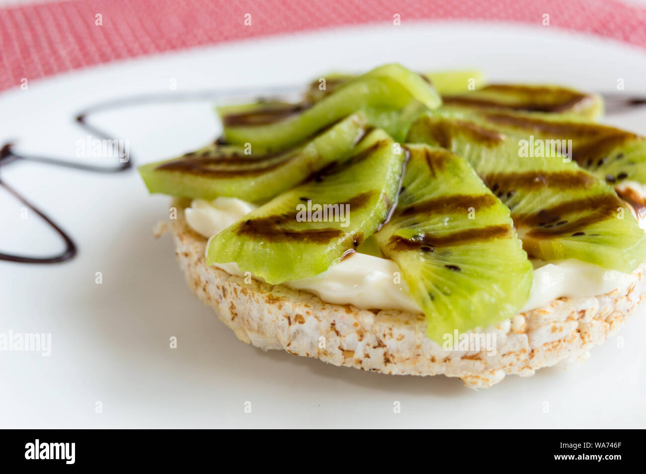 Rice biscuit with light cream cheese and slices of Kiwi. Healthy food ...