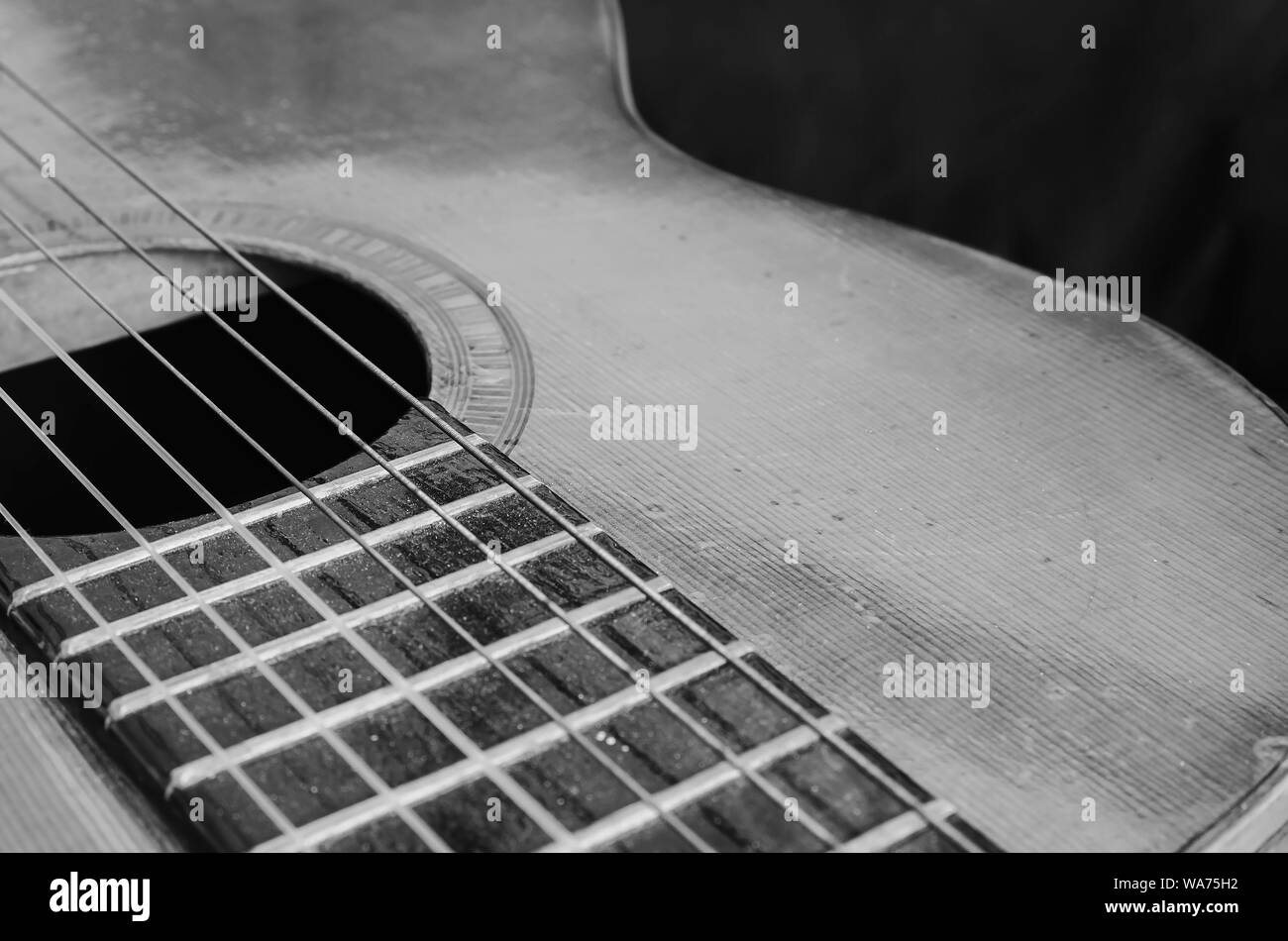 Details of an old acoustic guitar, the body curves, sound hole, frets ...