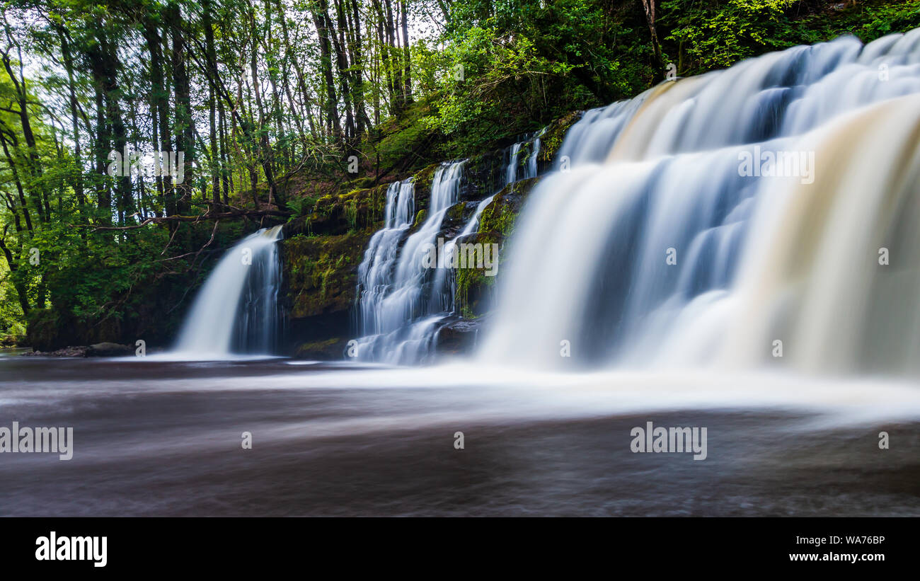 A scenic waterfall surrounded by forest in South Wales (Sgwd y Pannwr ...