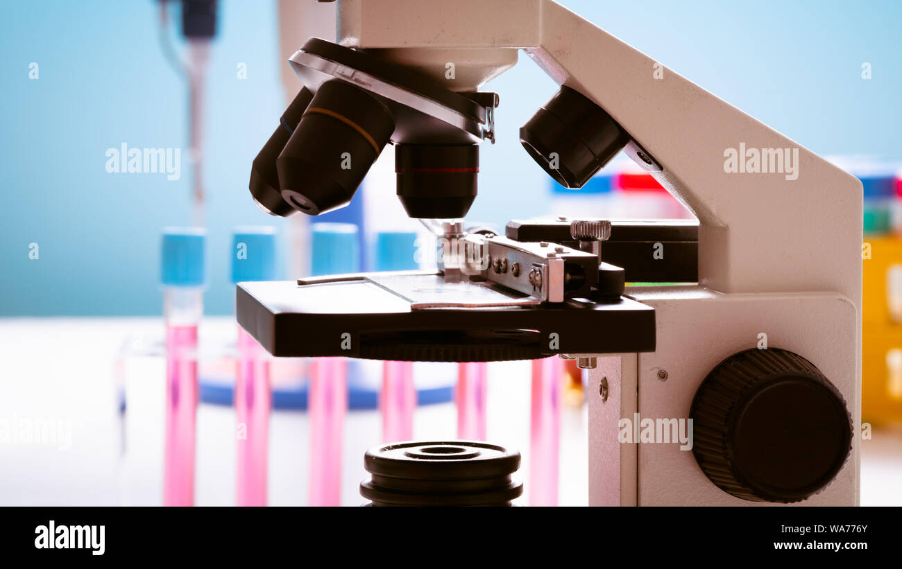 Microscope and test tubes on laboratoy table Stock Photo - Alamy