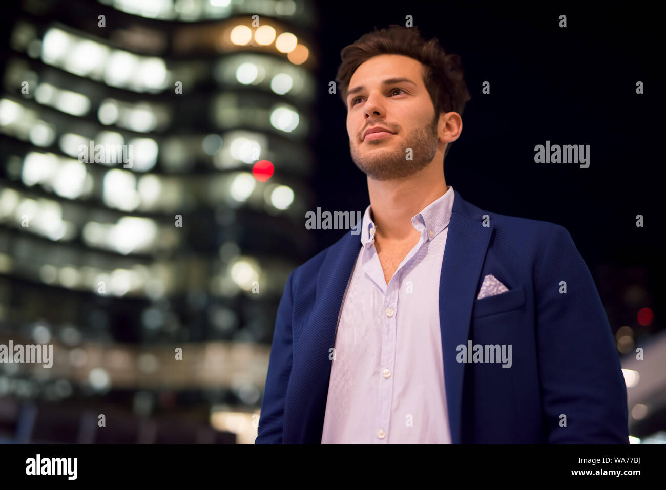Smiling young man walking outdoors at night Stock Photo - Alamy