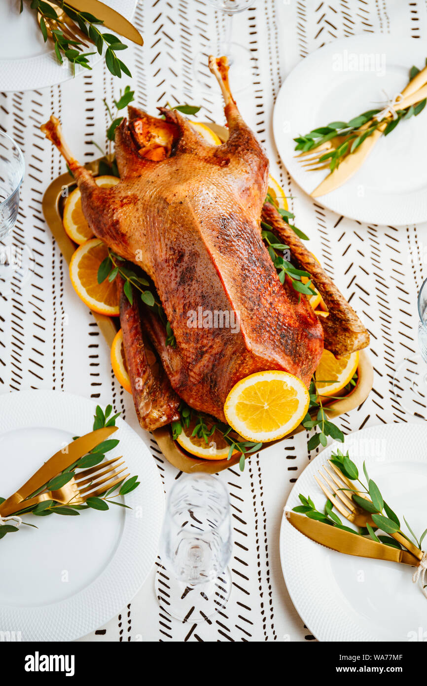 Festive table setting with whole roasted goose on a golden tray for ...