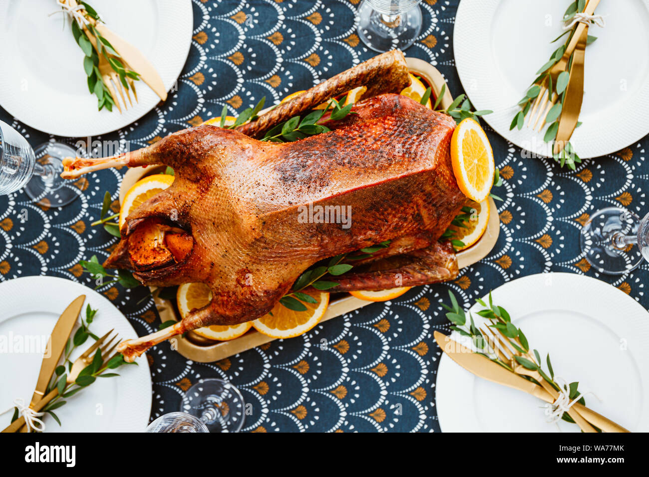 Festive table setting with whole roasted goose on a golden tray for ...