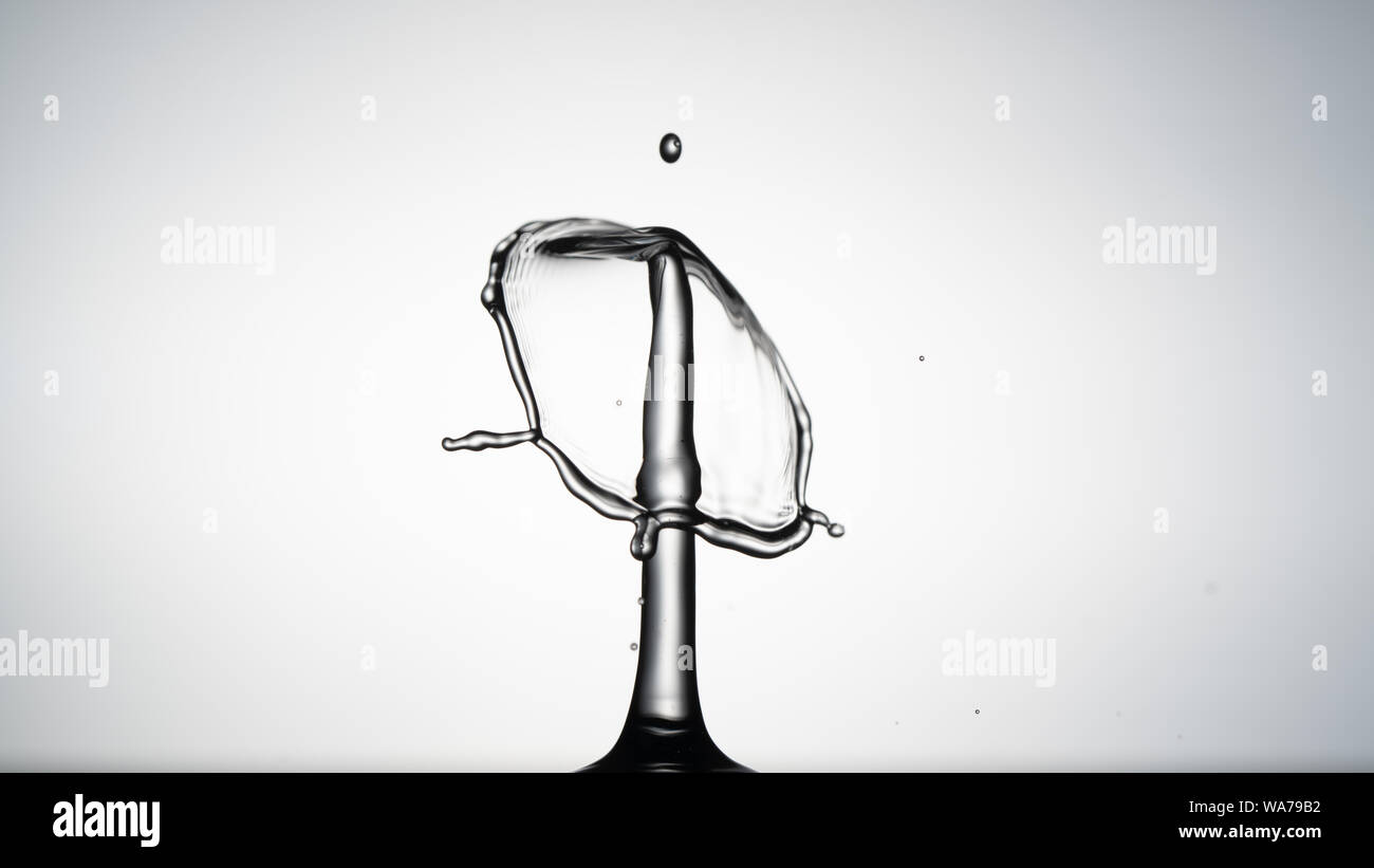 Close-up of a water drop falling on water surface Stock Photo - Alamy