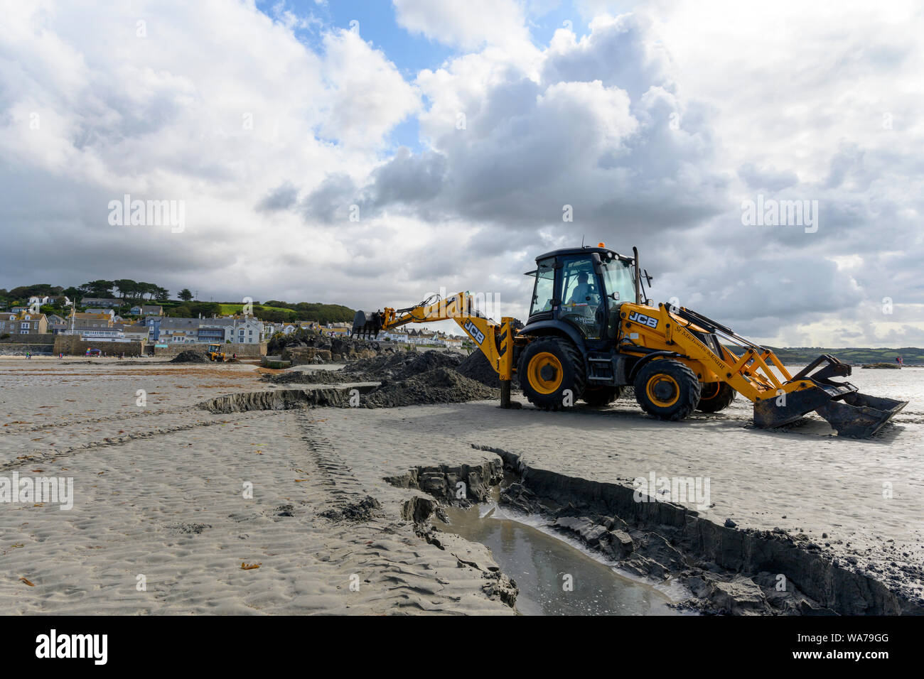JCB diggers, digging a channel in the sand for tourist ferry boats, St ...