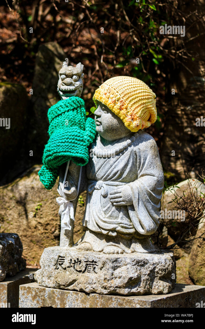 Japan, Miyajima. Daisho-in temple. Small stone Jizo statue of standing ...