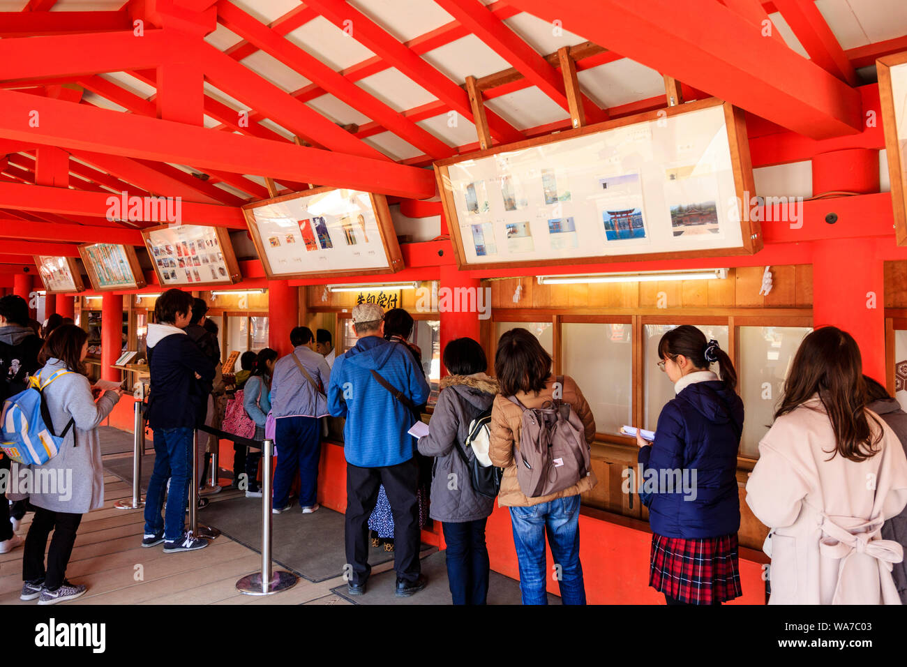 Japan, Miyajima. Itsukushima Shrine. Interior of shrine. People queuing ...